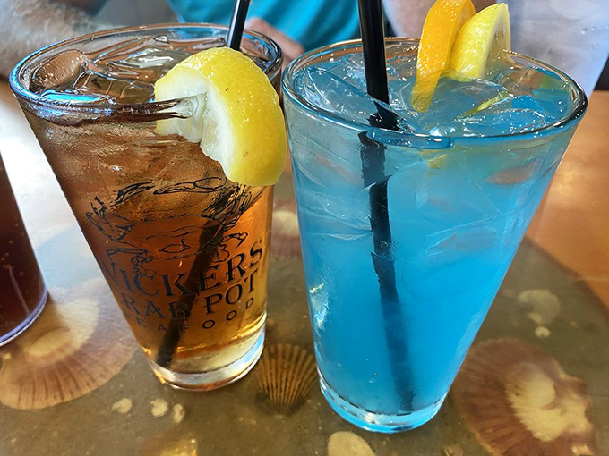 Dueling cocktails in coastal colors—one amber, one azure—promising a perfect pairing with whatever emerges from the kitchen's steamy depths.