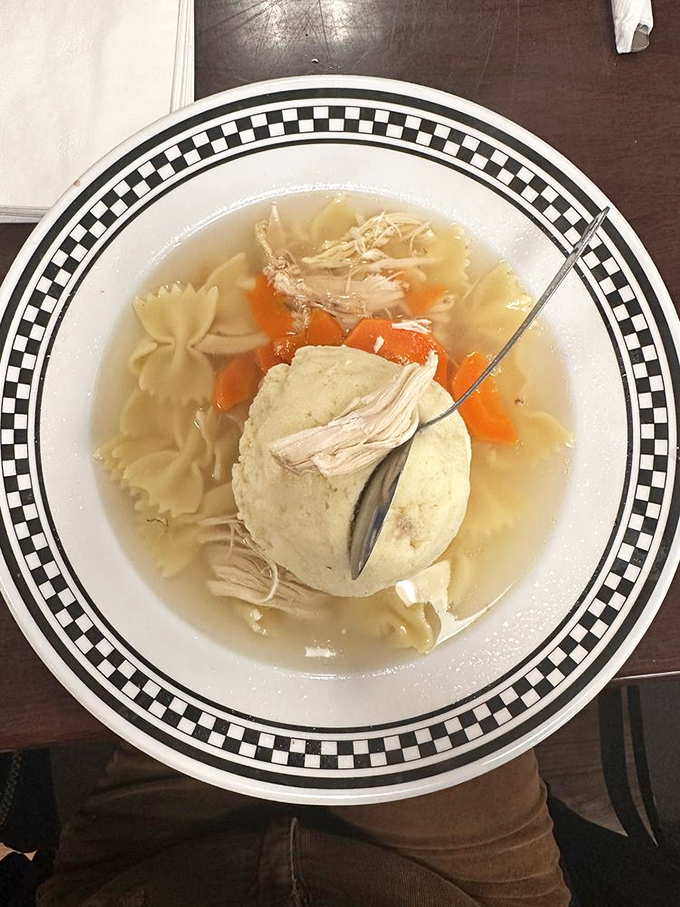 This isn't just soup—it's a floating matzo ball island in a sea of golden chicken broth that could cure everything from colds to existential crises.