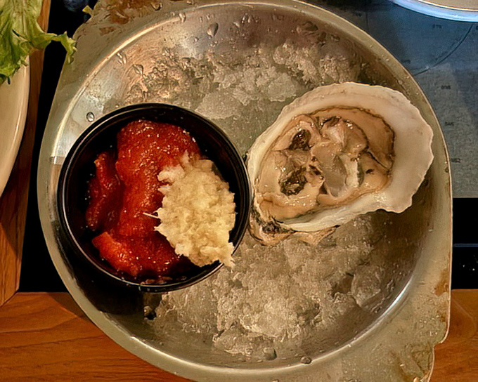 An oyster on the half shell with classic accompaniments. Nature's perfect appetizer—briny, mineral-rich, and requiring absolutely no improvement from the kitchen.
