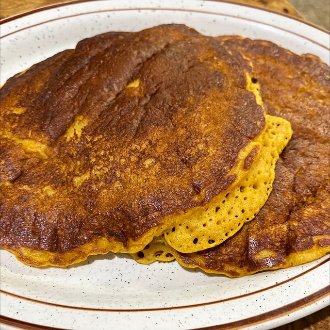 Pumpkin pancakes that taste like autumn had a beautiful accident with breakfast. The color alone tells you these aren't your average flapjacks.