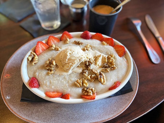 Not just oatmeal, but a canvas of comfort—crowned with fresh strawberries, walnuts, and a scoop of ice cream melting into warm porridge.