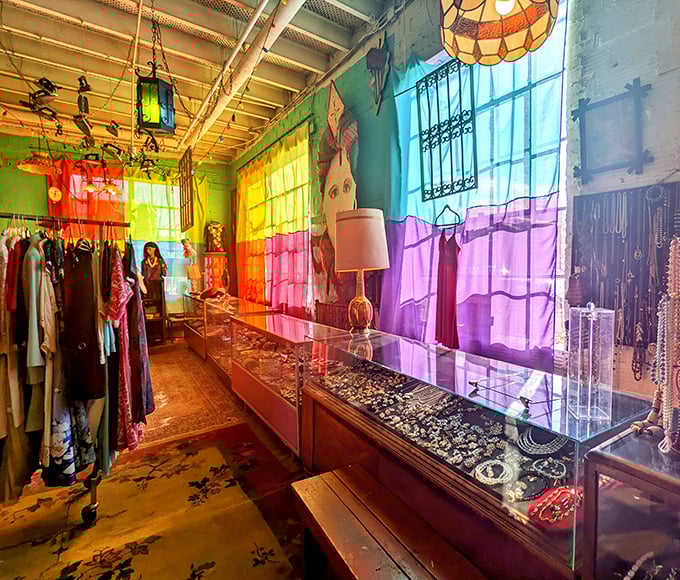 Rainbow curtains filter sunlight onto vintage jewelry displays, creating a treasure hunt atmosphere that makes shopping feel like an adventure.