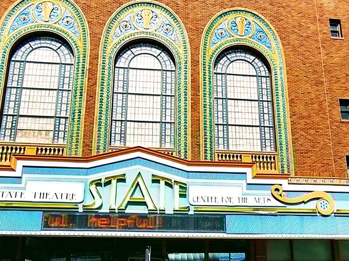 The State Theatre's marquee glows with Art Deco splendor. Those ornate windows aren't just showing off—they're reminding us how they built things "back in the day."
