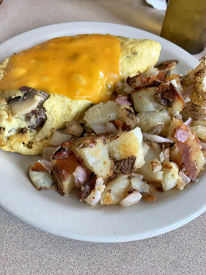 An omelet that doesn't just contain cheese—it embraces it completely, with a side of potatoes that could make an Irishman weep with joy.