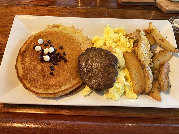 The breakfast trinity: golden pancakes, fluffy eggs, and seasoned potatoes. Add sausage and you've got a plate that could fuel a marathon—or a serious nap.