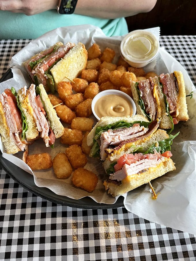 Club sandwiches are the Swiss Army knives of lunch—reliable, multi-layered, and perfectly paired with golden tater tots that crunch like happiness itself.