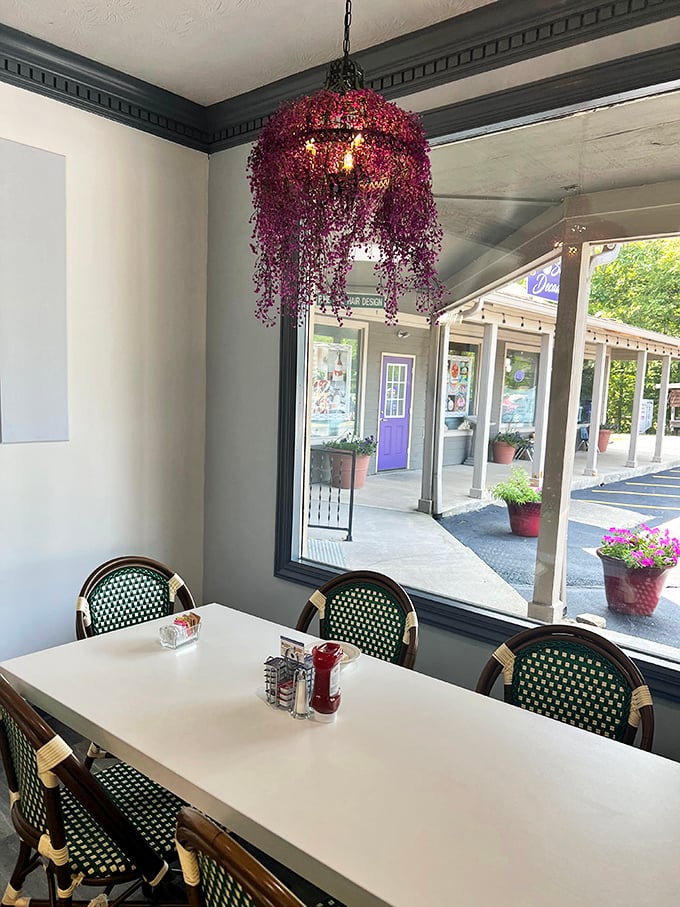 The window seat with its whimsical hanging floral light fixture offers prime people-watching with a side of small-town charm.