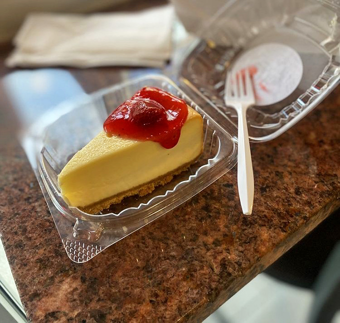 A slice of cheesecake with strawberry topping—because after conquering a mountain of chicken, you've earned this sweet victory lap.