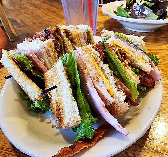 A club sandwich stacked higher than your weekend to-do list, with layers of fresh ingredients that make lunch the day's main event rather than an afterthought.