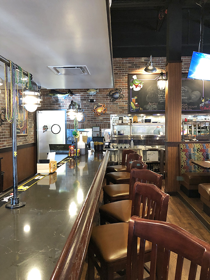 The counter view reveals the heart of Gulf Shores—where seafood dreams are crafted and Mardi Gras beads hang like promises of good times ahead.