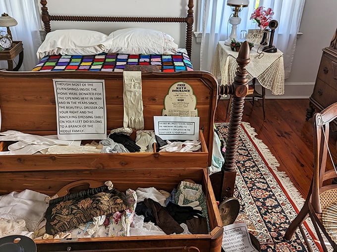 An open trunk displaying the intimate possessions of former residents. The colorful quilt provides a surprising pop of cheer in this otherwise solemn collection.