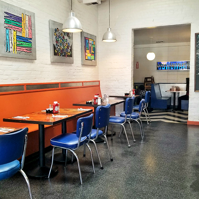 The dining room feels like the coolest friend's kitchen—if that friend had impeccable taste in art and color schemes. Orange and blue never looked so appetizing.