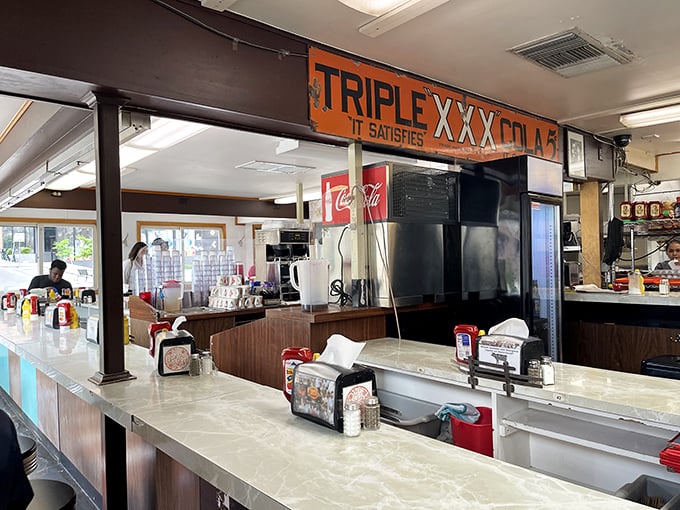 The counter isn't just where food is served—it's where stories are exchanged, friendships are formed, and the community gathers under the watchful eye of vintage signage.