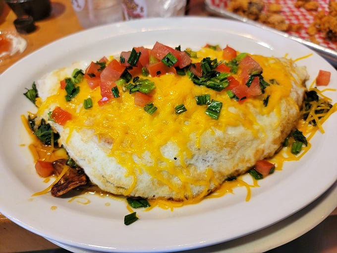 This isn't just an omelet—it's a cheese-draped sunrise on a plate, complete with fresh toppings that make breakfast feel like the celebration it should be.
