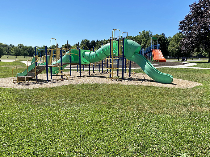 This playground's twisting green slides promise the kind of old-school childhood joy that no video game can replicate – pure gravitational delight.