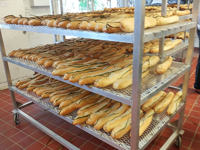 The bread racks reveal La Segunda's secret weapon—those palm fronds create the signature split top. Carb-counters, avert your eyes or abandon all resolve.