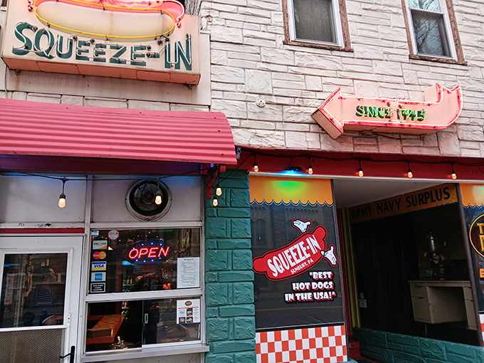 The iconic hot dog-shaped sign beckons like a neon lighthouse for the hungry. Squeeze-In's mint-green facade stands as a delicious time capsule on Market Street.