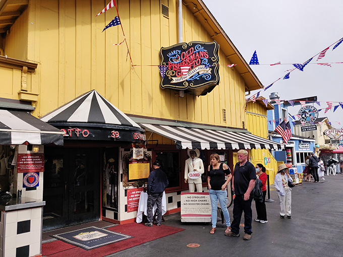 The cheerful yellow exterior of Old Fisherman's Grotto stands like a beacon of culinary promise, complete with a whimsical fisherman statue greeting hungry visitors.