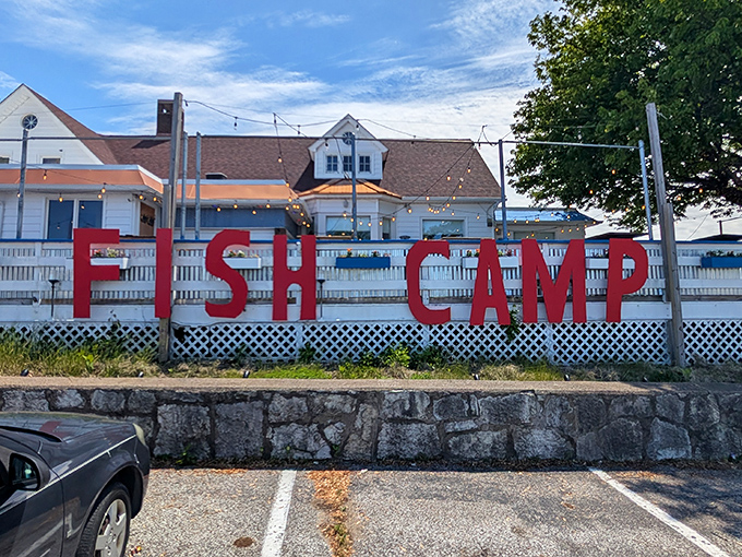 The bold red "FISH CAMP" sign against the white building is like a lighthouse for hungry souls—guiding seafood pilgrims to their delicious destination.