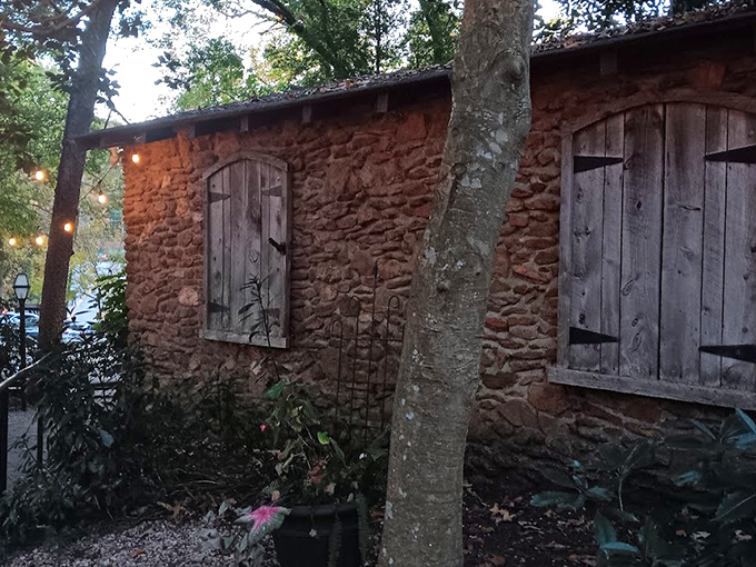 A stone cottage nestled among towering trees isn't just fairy tale scenery—it's your first clue that The Peddler isn't your average strip mall steakhouse.