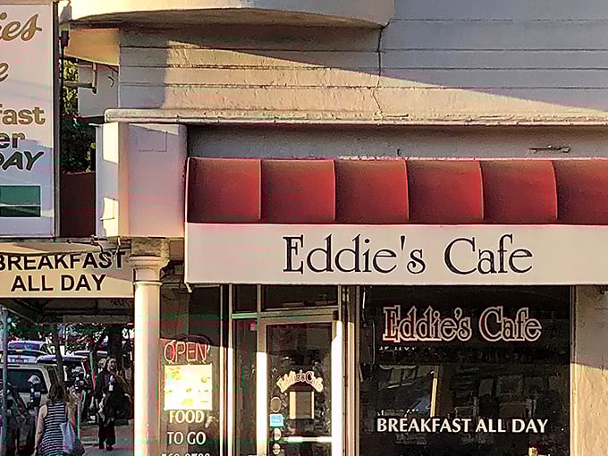 The iconic red-cushioned exterior of Eddie's Café promises breakfast salvation, standing like a beacon for hungry San Franciscans on Divisadero Street.