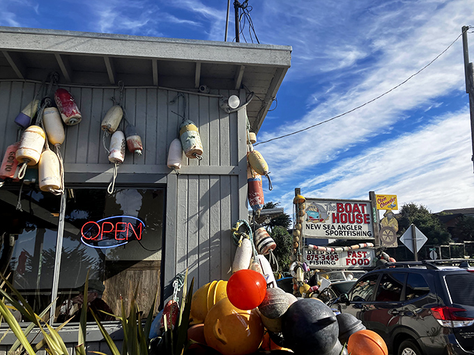 Colorful buoys dangle like maritime Christmas ornaments from this weathered gray shack. The neon "OPEN" sign promises seafood treasures await inside.