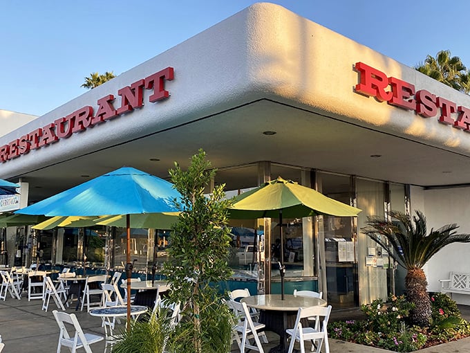 Mid-century modern meets palm tree paradise at this North Hills gem. The outdoor patio beckons with blue umbrellas and California sunshine.