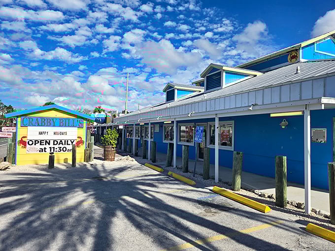 The colorful exterior of Crabby Bill's screams "Florida seafood joint" with its vibrant picnic tables and that iconic crab sign beckoning hungry beachgoers.