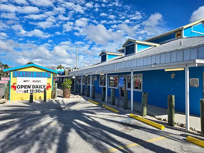 The colorful exterior of Crabby Bill's screams "Florida seafood joint" with its vibrant picnic tables and that iconic crab sign beckoning hungry beachgoers.