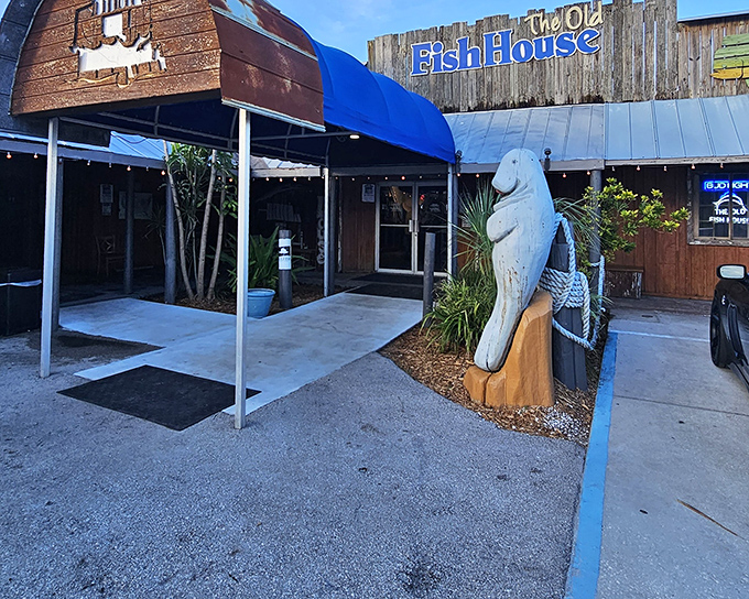 The weathered wooden exterior and manatee statue aren't trying to impress anyone—they're too busy guarding decades of authentic Florida flavor inside.