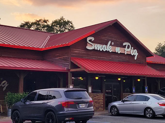 The rustic wooden exterior with its signature red roof stands like a BBQ beacon. Come hungry, leave happy—and possibly in need of elastic waistbands.