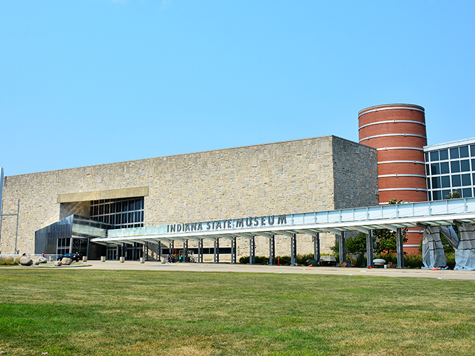 The limestone façade of the Indiana State Museum stands proudly against a blue sky, its modern design blending seamlessly with Indiana's geological heritage.