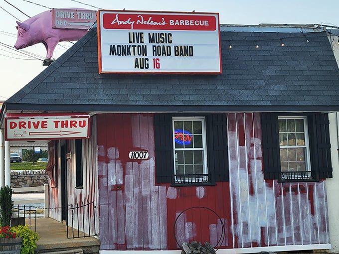 The giant pink pig on the roof isn't just decoration – it's a beacon of barbecue hope guiding hungry travelers to this rustic red barn-like paradise.
