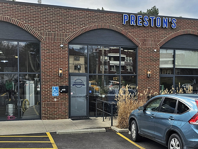 Preston's brick exterior with those signature blue umbrellas isn't just inviting—it's practically whispering "get in here and try these burgers already!"
