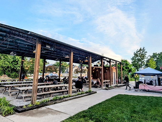 The outdoor patio at Eli's BBQ is where summer dreams come true—string lights, wooden beams, and wildflowers creating the perfect backdrop for smoky indulgence. 