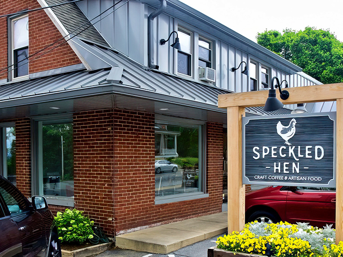 The unassuming brick exterior of Speckled Hen hides culinary treasures within. That wooden sign promises craft coffee and artisan food—spoiler alert: it delivers both spectacularly.