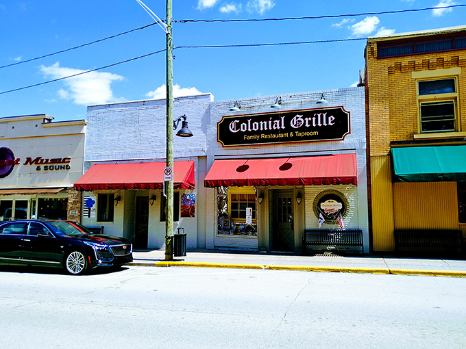 The classic brick façade and red awnings of Colonial Grille stand as a beacon of breakfast hope on Irwin's Main Street, promising comfort food salvation to hungry travelers.