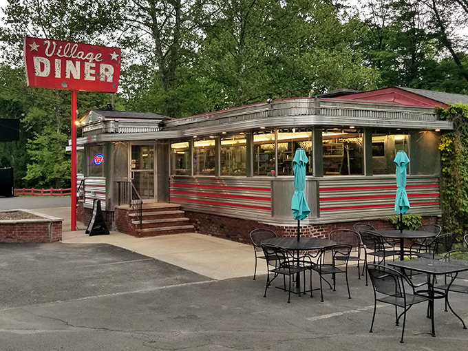The classic stainless steel exterior with red trim announces you've arrived somewhere special—a genuine slice of Americana waiting in Milford.