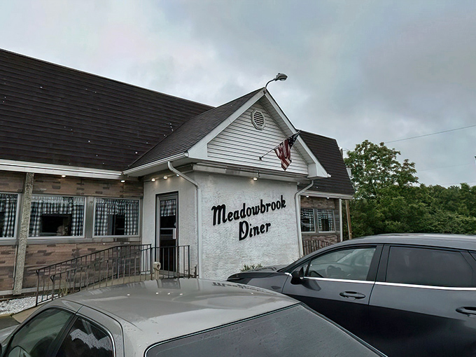 The classic American flag above Meadowbrook Diner isn't just decoration—it's a promise that inside awaits the kind of breakfast that made this country great.