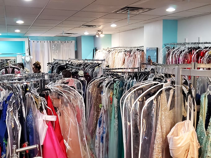 A rainbow of formal wear awaits, each gown protected like a celebrity before the red carpet. Fashion dreams in plastic cocoons.