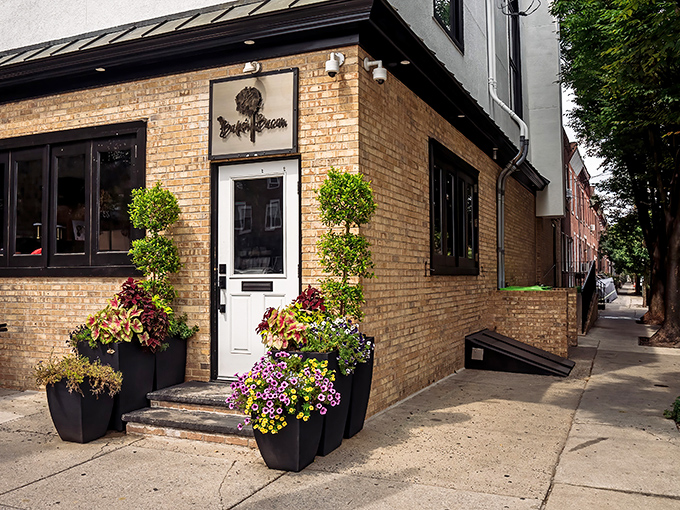 The unassuming brick exterior hides Philadelphia's pork paradise like a culinary speakeasy. Those planters aren't just pretty—they're guarding the gateway to flavor town.