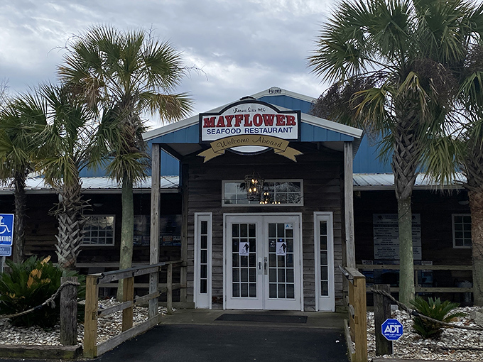 Palms standing guard at this maritime haven, the Mayflower's blue-trimmed facade promises seafood treasures within, no passport required.