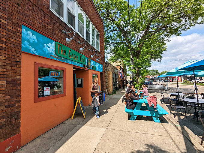 The vibrant turquoise facade of The Green Owl Cafe stands out like a cheerful oasis on Atwood Avenue, complete with its whimsical owl mascot.