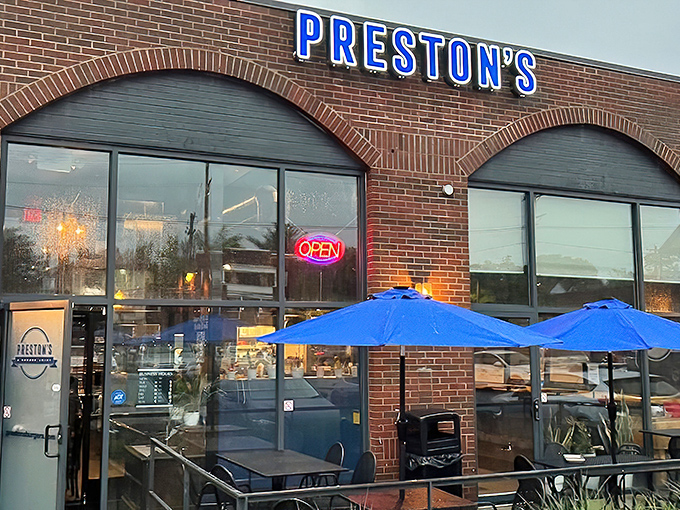 Preston's brick exterior with those signature blue umbrellas isn't just inviting—it's practically whispering "get in here and try these burgers already!"