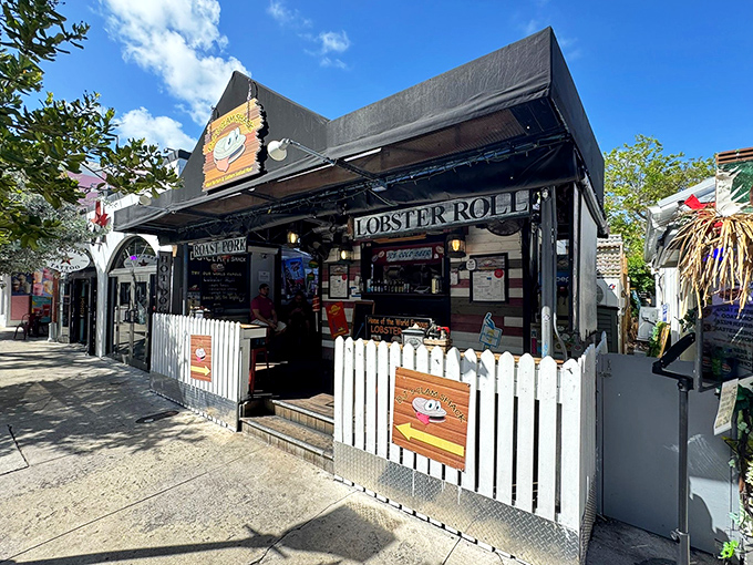 The white picket fence isn't keeping secrets in—that cartoon clam with googly eyes is practically winking at passersby, promising seafood magic within.