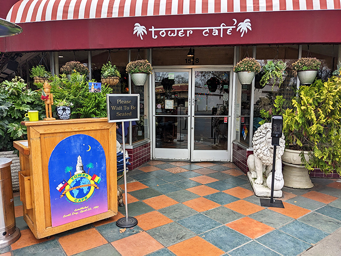 The entrance to Tower Café feels like stumbling upon a secret garden oasis, complete with guardian statues and a red awning that practically winks at you.