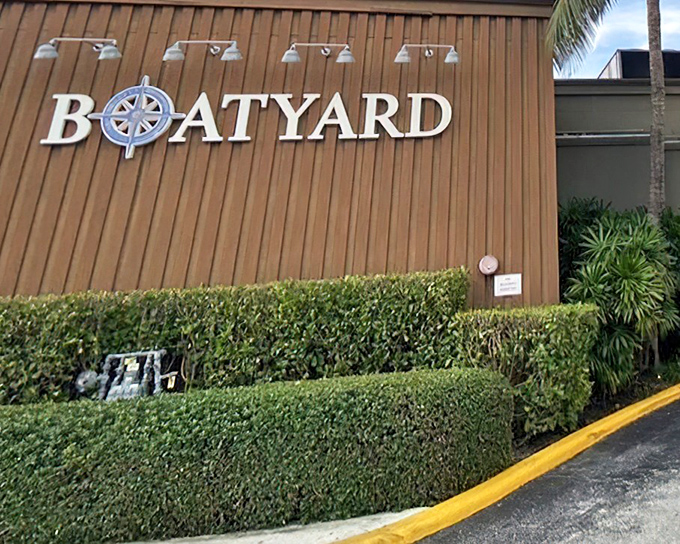 The nautical-inspired exterior of Boatyard welcomes seafood lovers with its compass logo and meticulously maintained hedges—Florida dining with maritime flair.