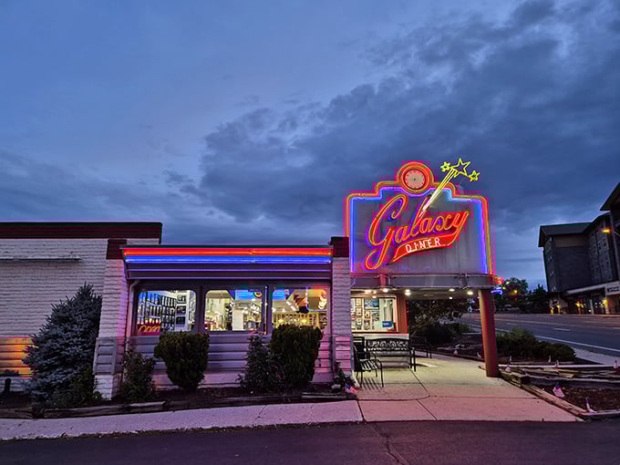 That neon glow against the twilight sky isn't just a sign—it's a time machine beckoning you to simpler days when calories didn't count and jukeboxes ruled.