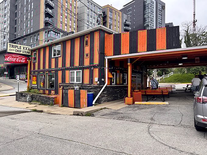 The iconic orange and black stripes of Triple XXX stand defiant against modern architecture, like a time traveler refusing to leave 1950.