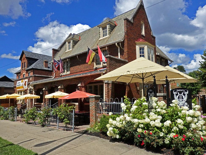 The stately brick exterior of Valter's welcomes visitors with colorful umbrellas, international flags, and blooming hydrangeas—Germany meets Midwest in architectural harmony.